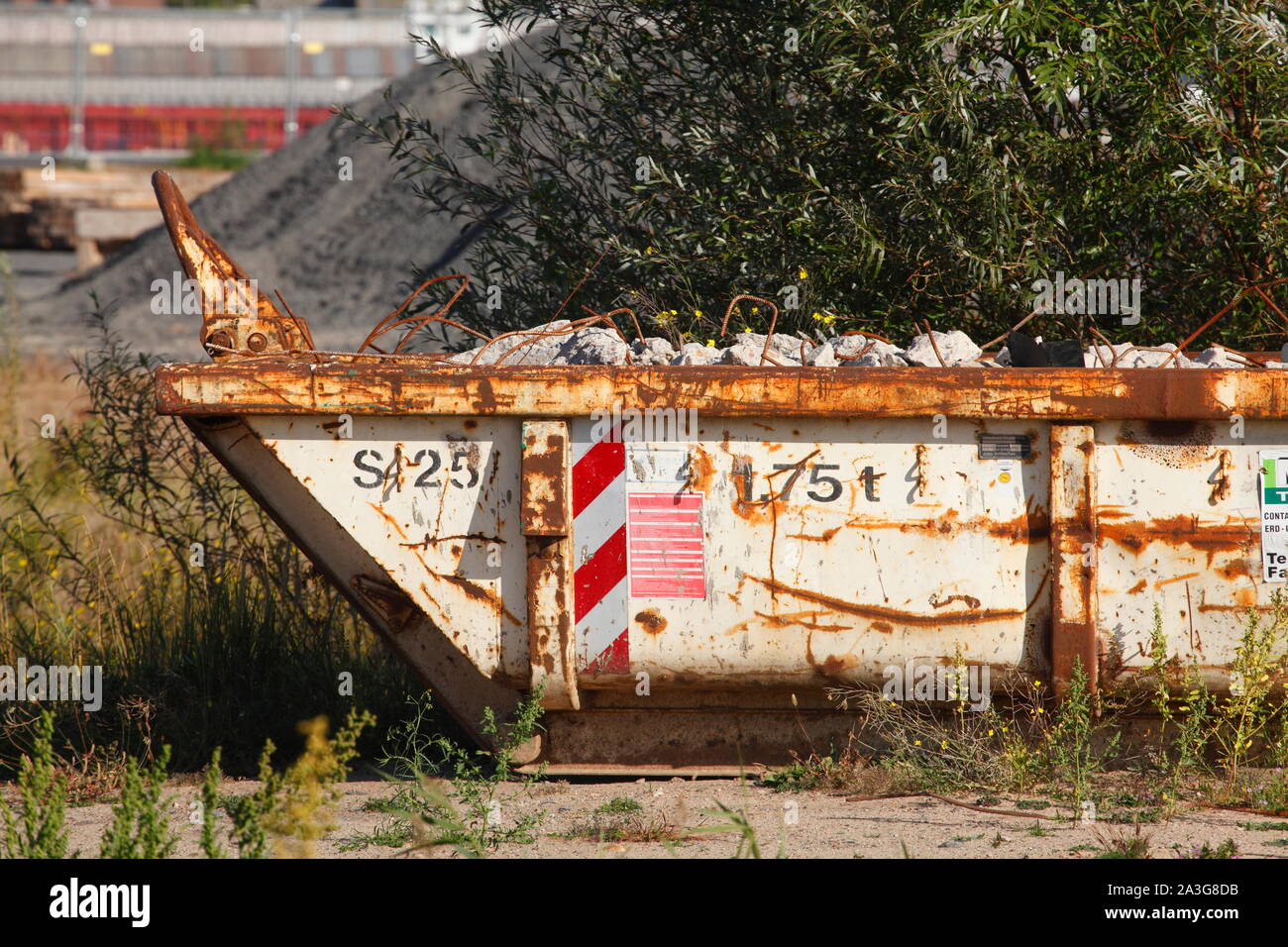 Old rusty settling trough for building rubble standing on a meadow ...