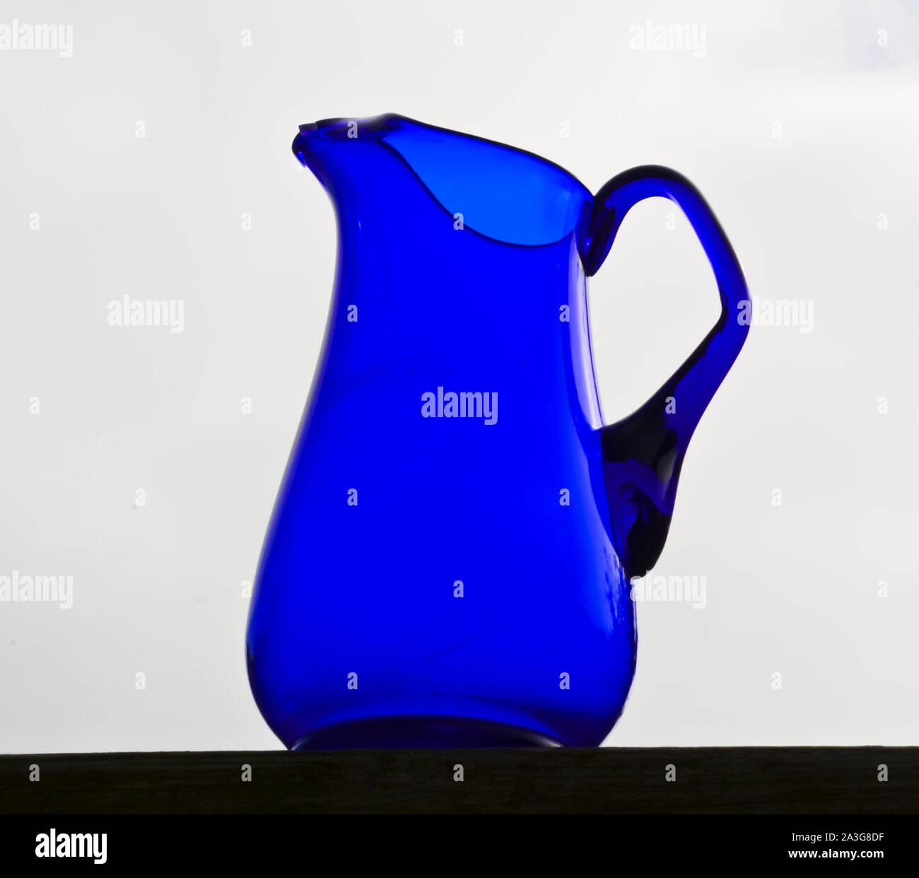 A jug of blue shining glass in front of a white background Stock Photo ...