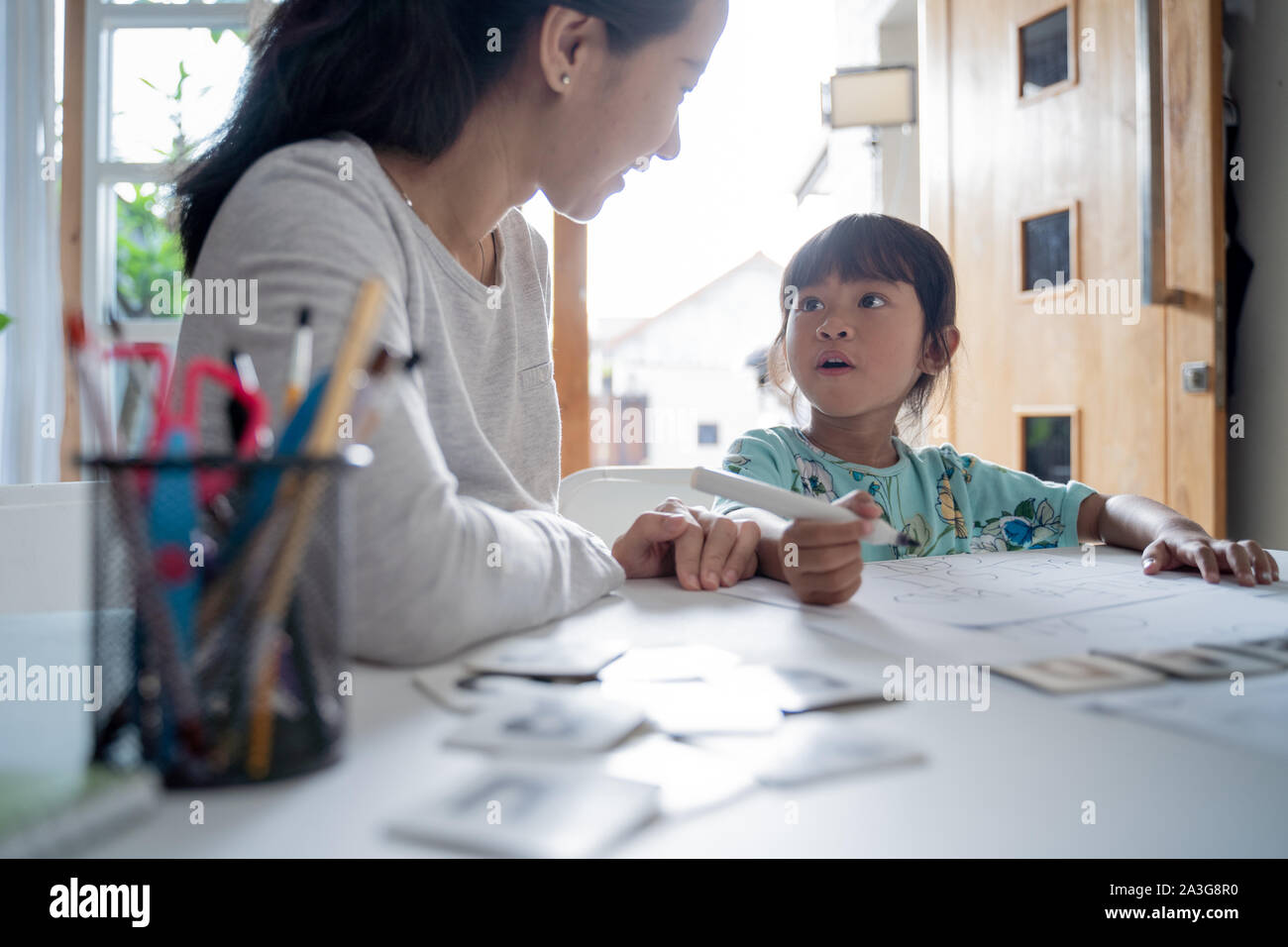 happy mother teaching her daughter the basic to read and write at home ...