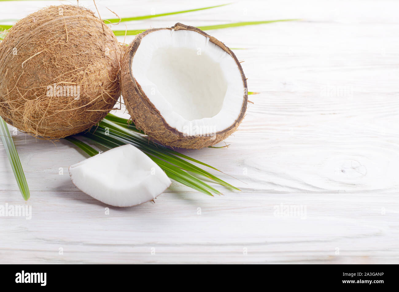 Coconut and shell pieces on white wooden table Stock Photo - Alamy