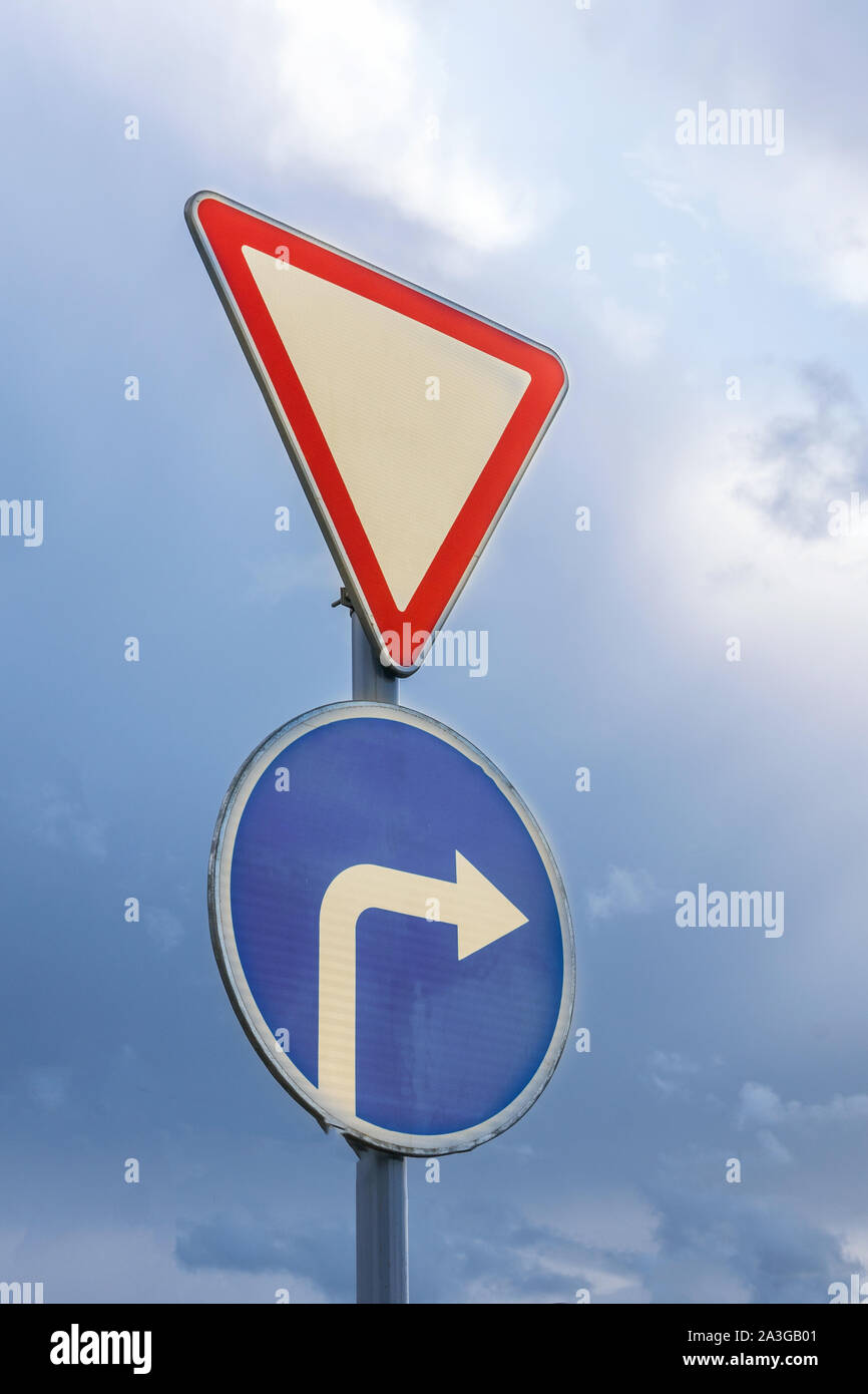 Give way and turn right, against the backdrop of dramatic sky and ...