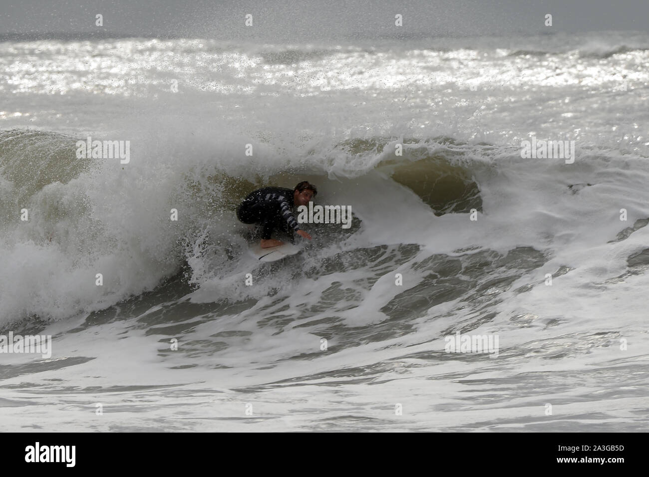 Tucking in for the tube on a barreling wave surfer Patrick Langdon Dark ...