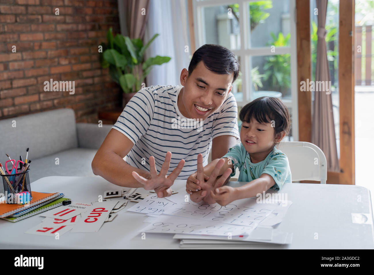 toddler learning math and counting with her father at home together ...