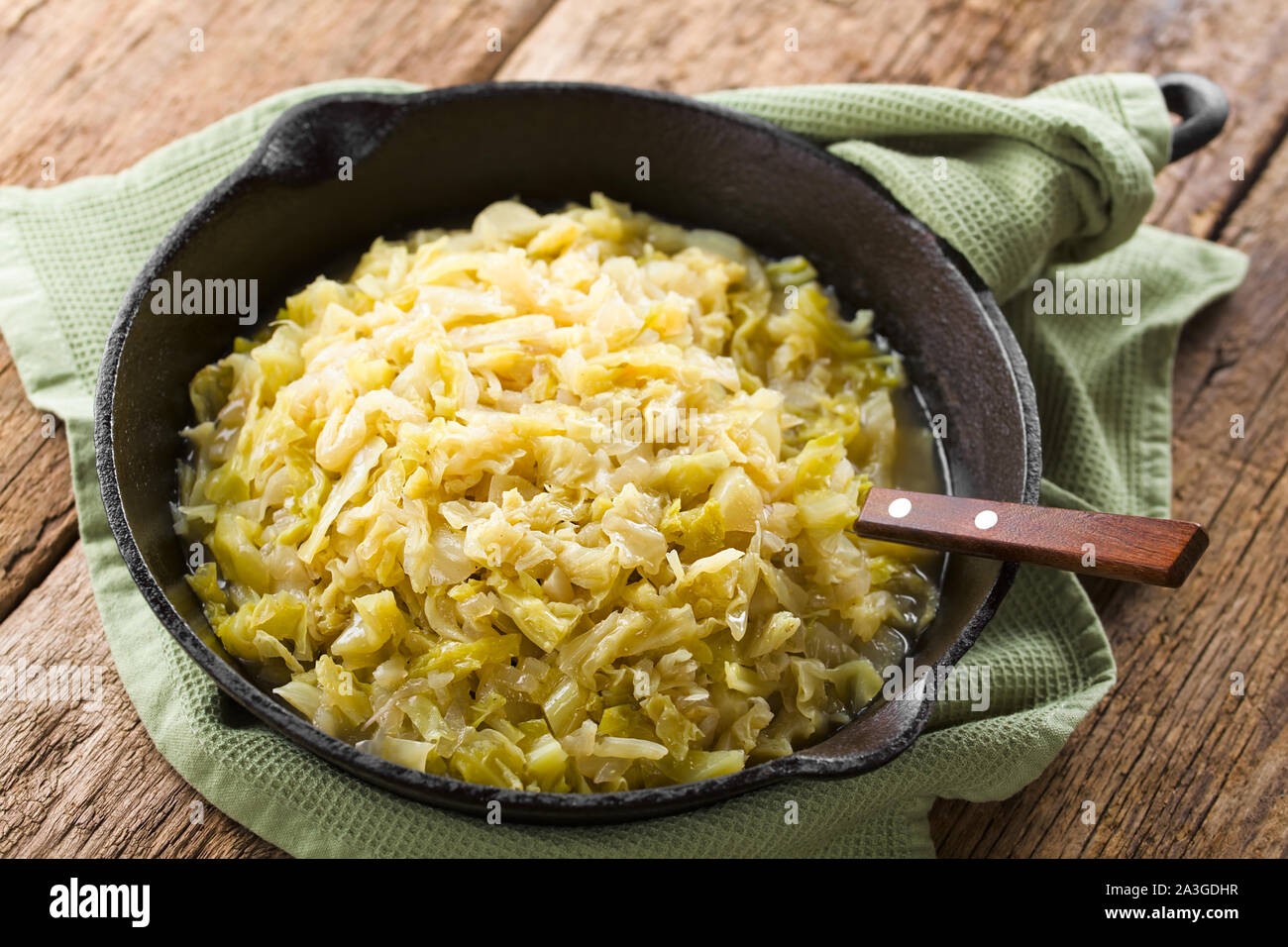 Fresh homemade braised white cabbage in cast iron skillet (Selective ...