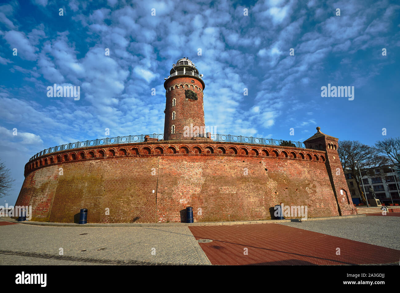 A red brick lighthouse at the entrance to the port in the city of ...