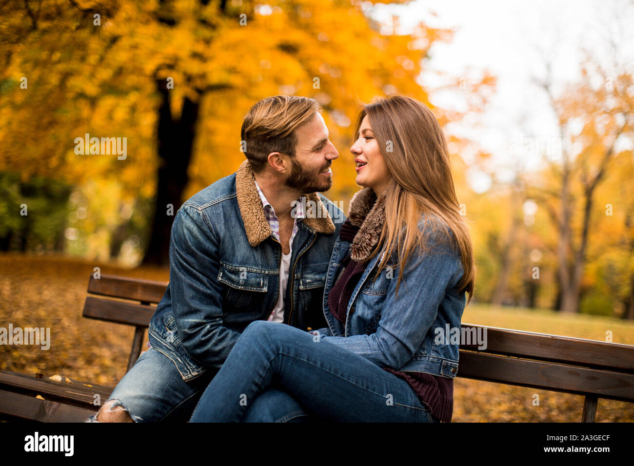 Romantic couple sit on bench in city park hi-res stock photography and ...