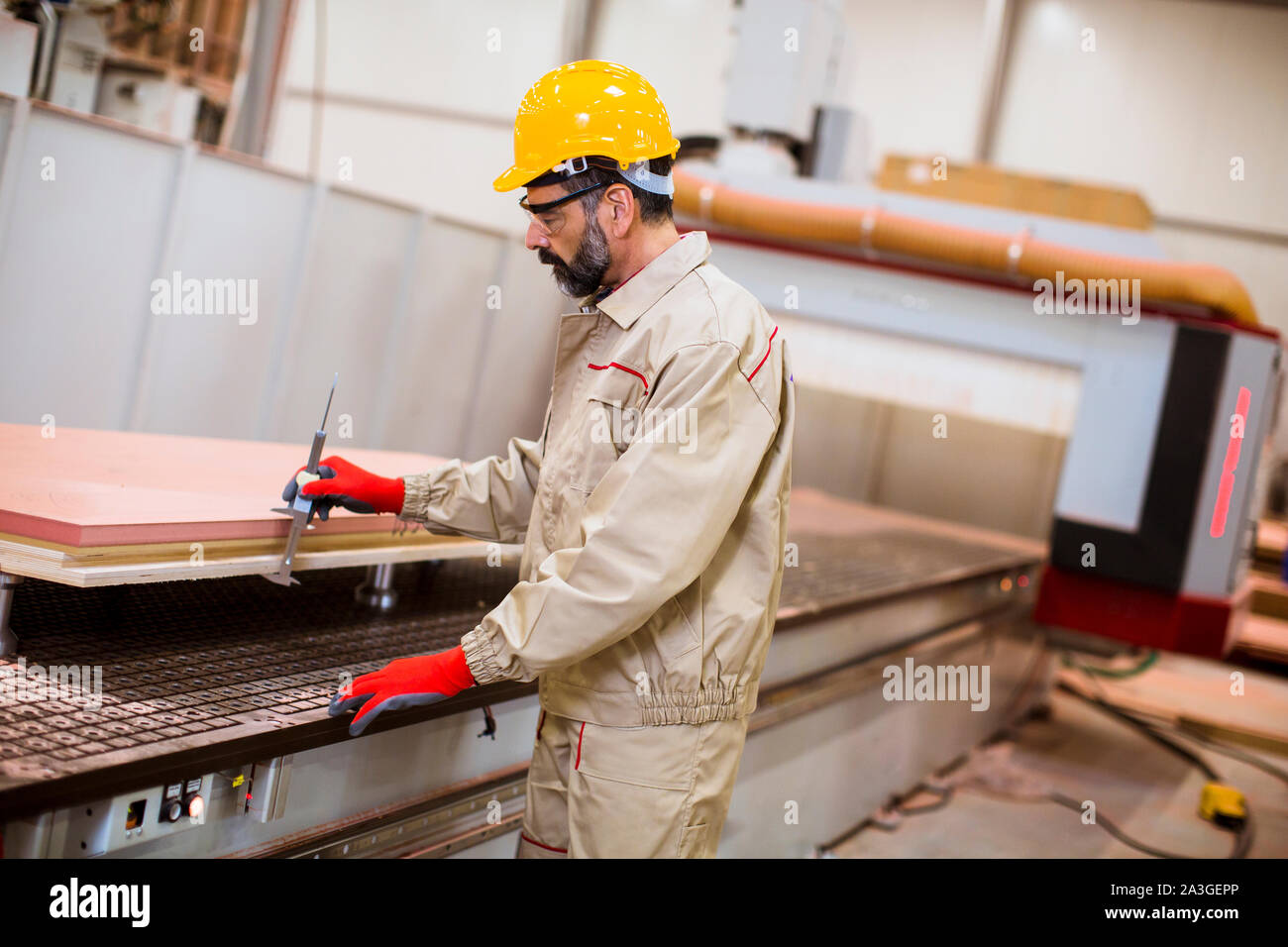 Portrait of senior man operating machine units in modern wooden factory ...