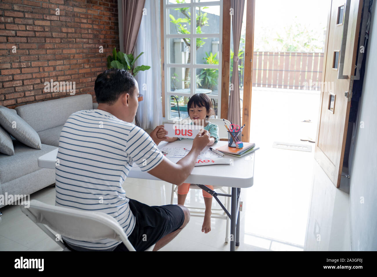 dad showing flash card with simple word to help her daughter to read ...