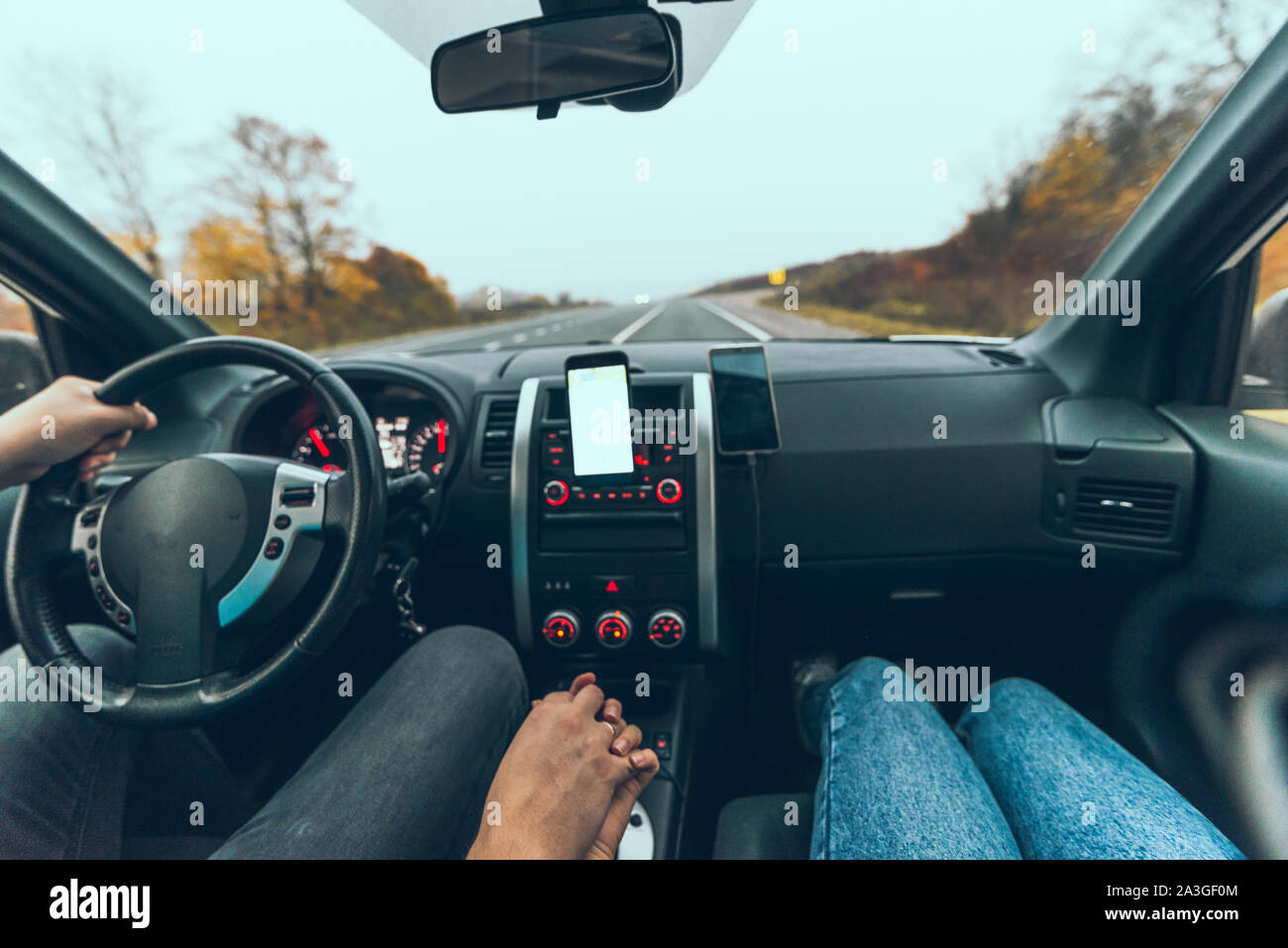 car travel concept autumn highway phone with white screen on dashboard ...