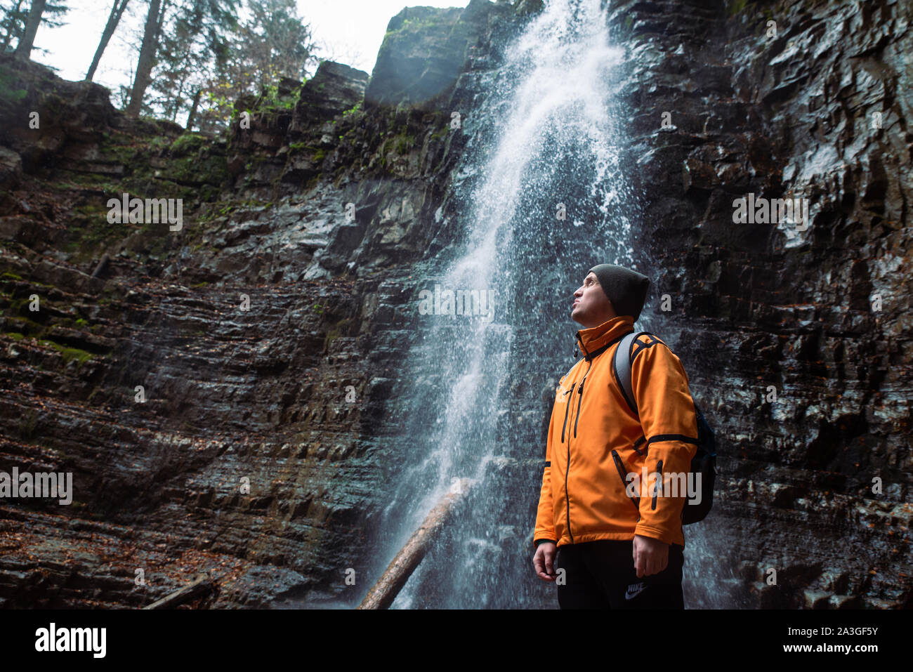 man hiking concept looking at waterfall in dip forest Stock Photo - Alamy