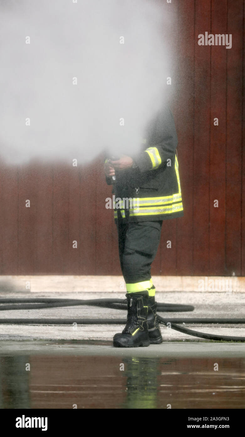 firefighter during the fire extinguishing with the foam and boots Stock ...