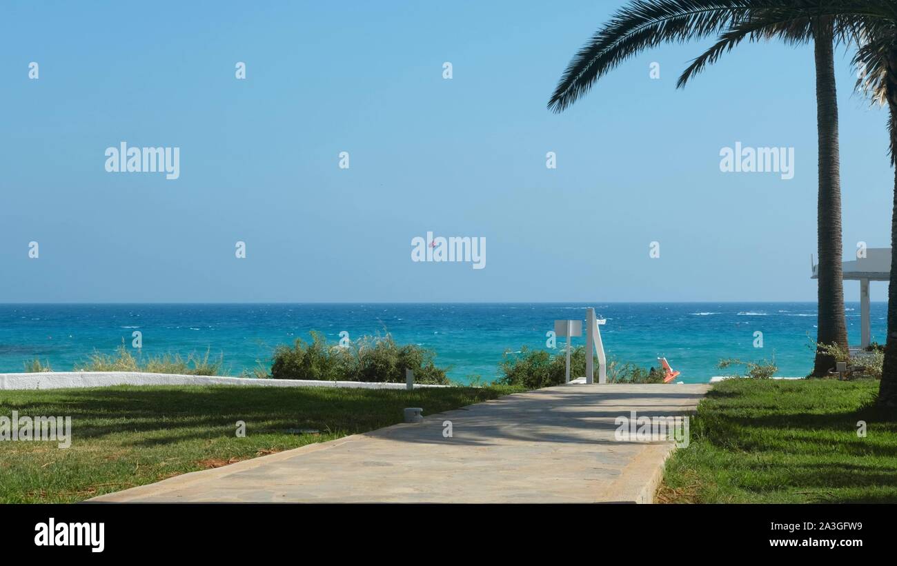 Path with palms leading to the beach of the azure mediterranean sea and ...