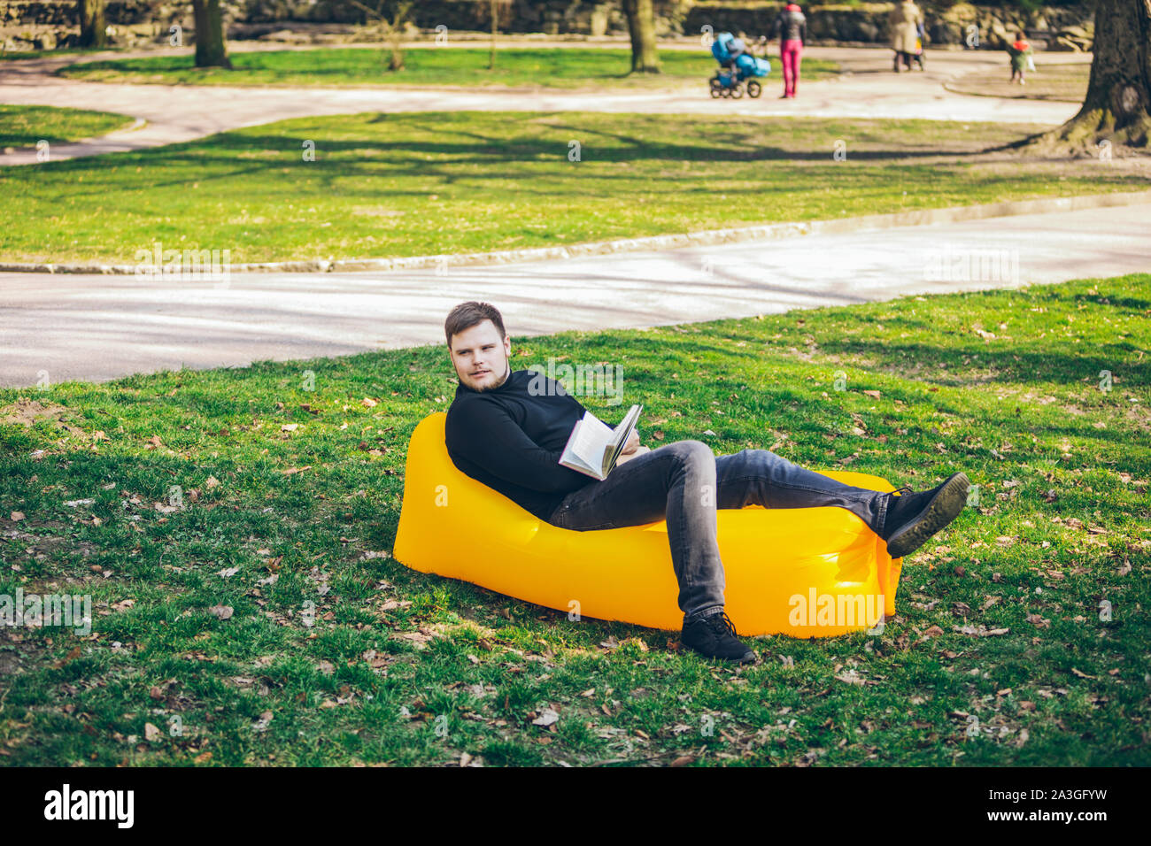 book reading concept. man in city park on inflatable mattress Stock ...