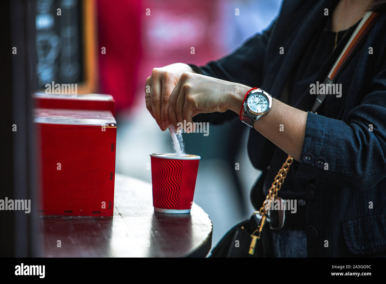 woman put sugar in red paper coffee cup Stock Photo - Alamy