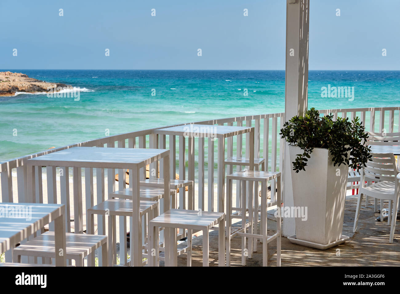 Close-up shot of a nice cafe with white chairs and tables located at ...