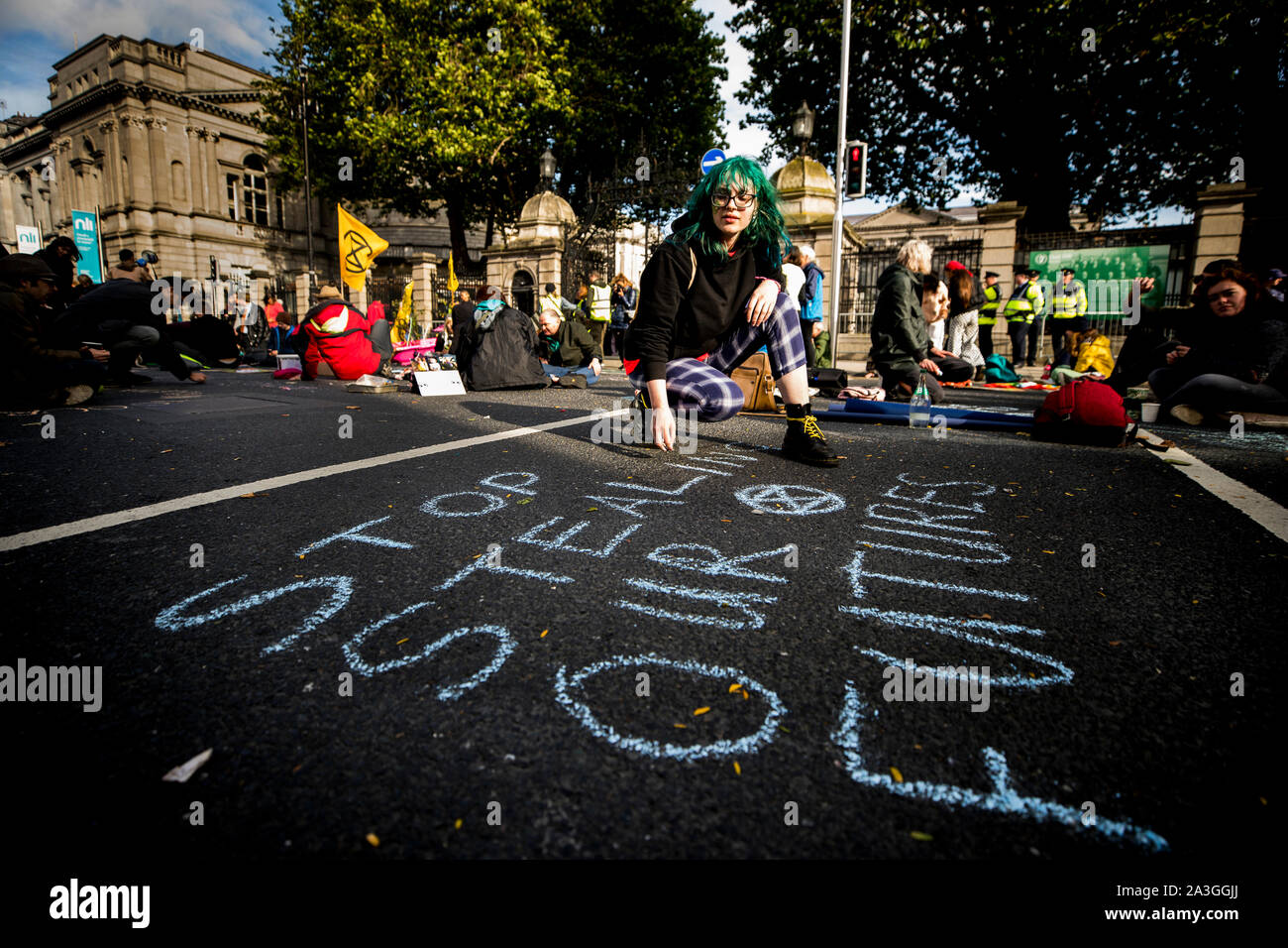 An Extinction Rebellion activist writing a message on the road during a ...