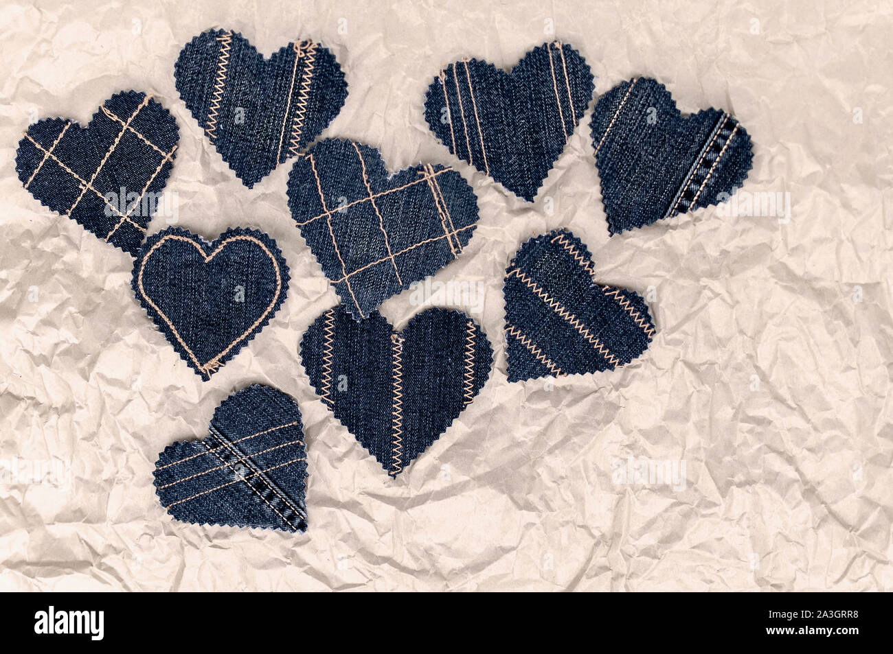 Hand made Jeans hearts on a crumpled craft paper background. Flat lay ...