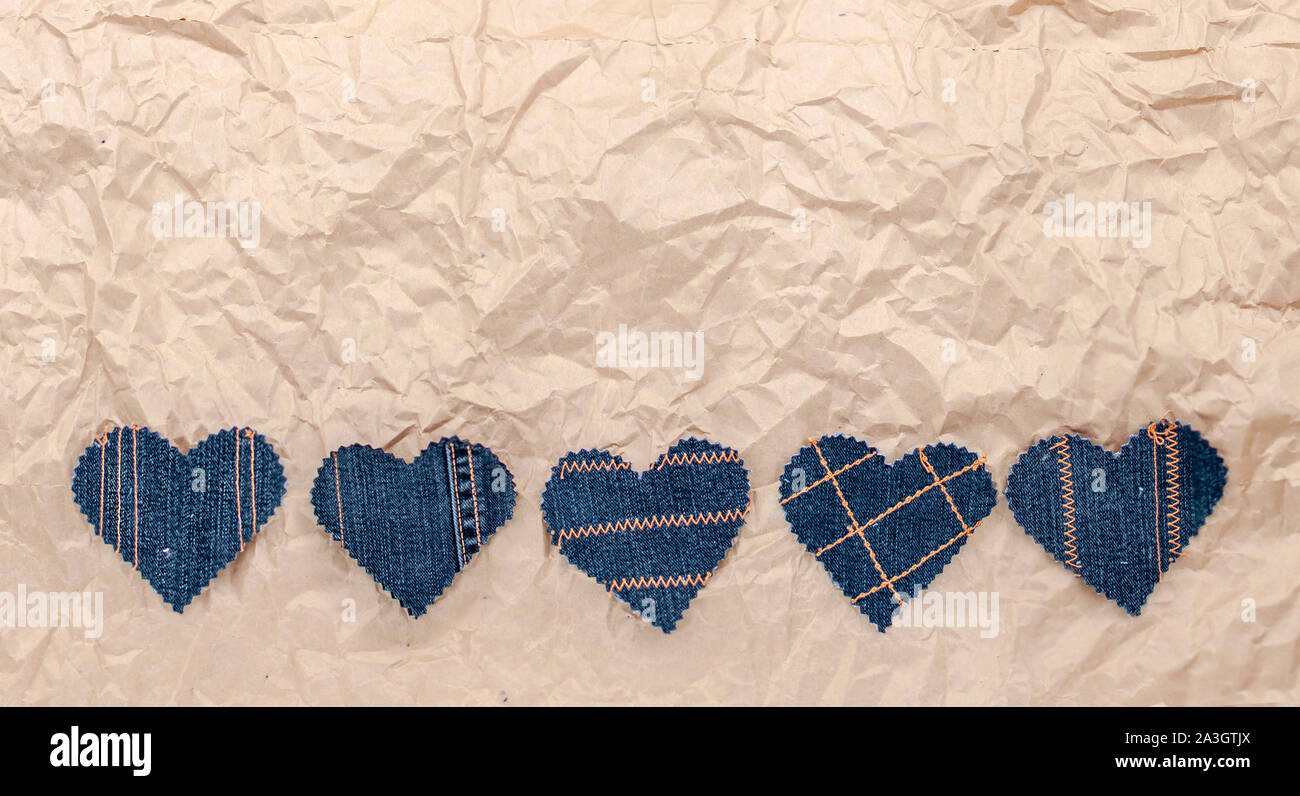 Hand made Jeans hearts on a crumpled craft paper background. Flat lay ...