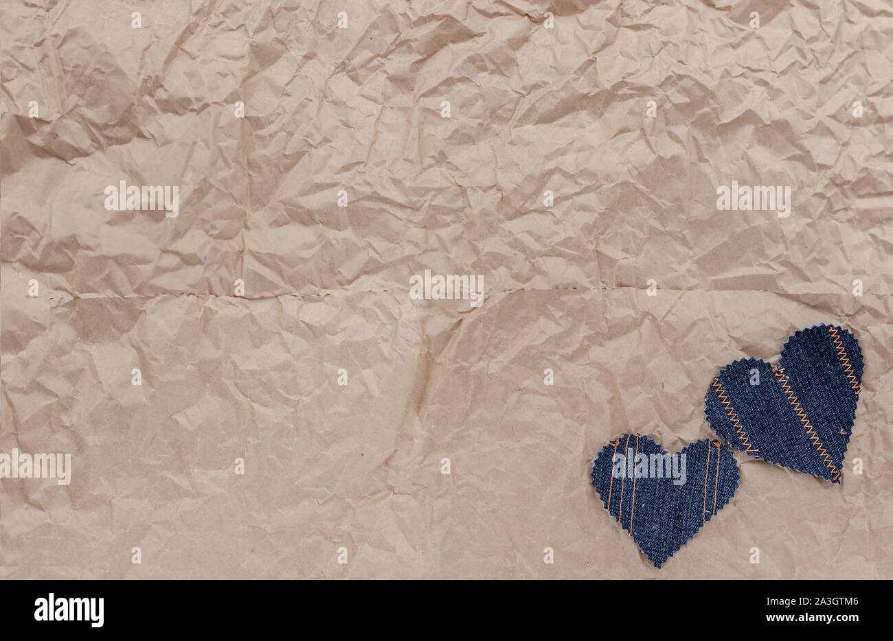 Hand made Jeans hearts on a crumpled craft paper background. Flat lay ...