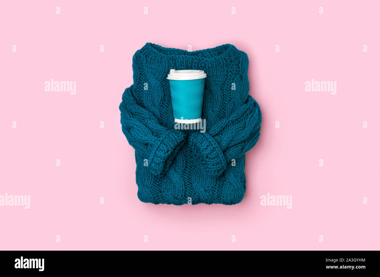 Flat lay top view turquoise cozy knit sweater with paper cup of coffee ...