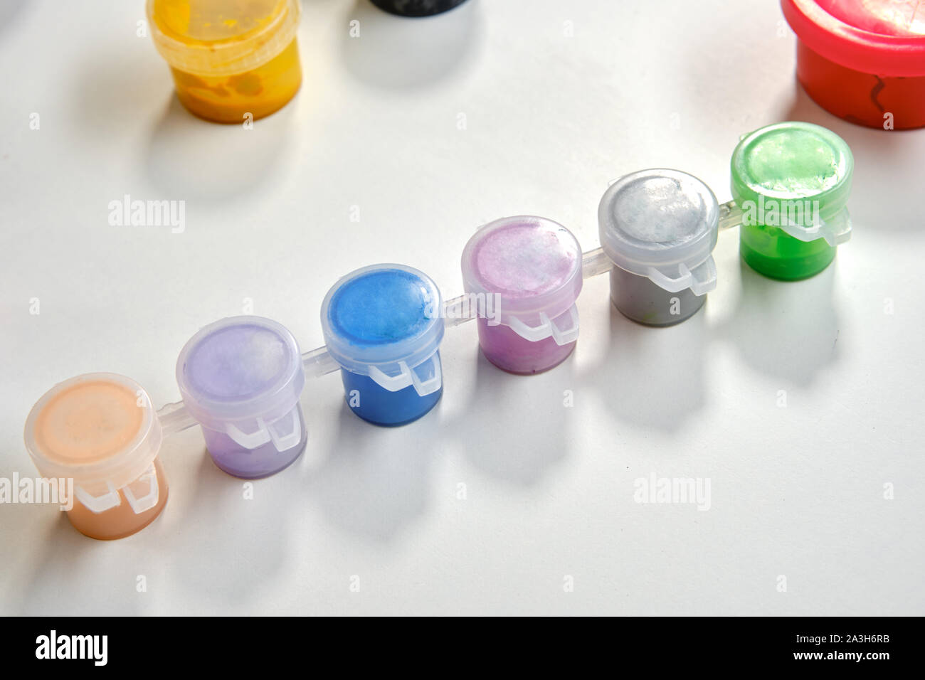 Colorful paints are standing on a table with a whatman. Art studio ...
