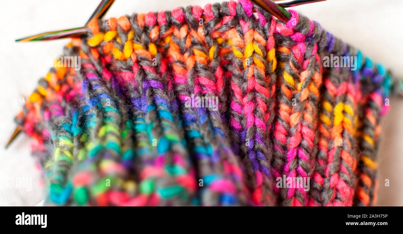 Knitting pattern texture, bright colorful yarn and needles close-up ...