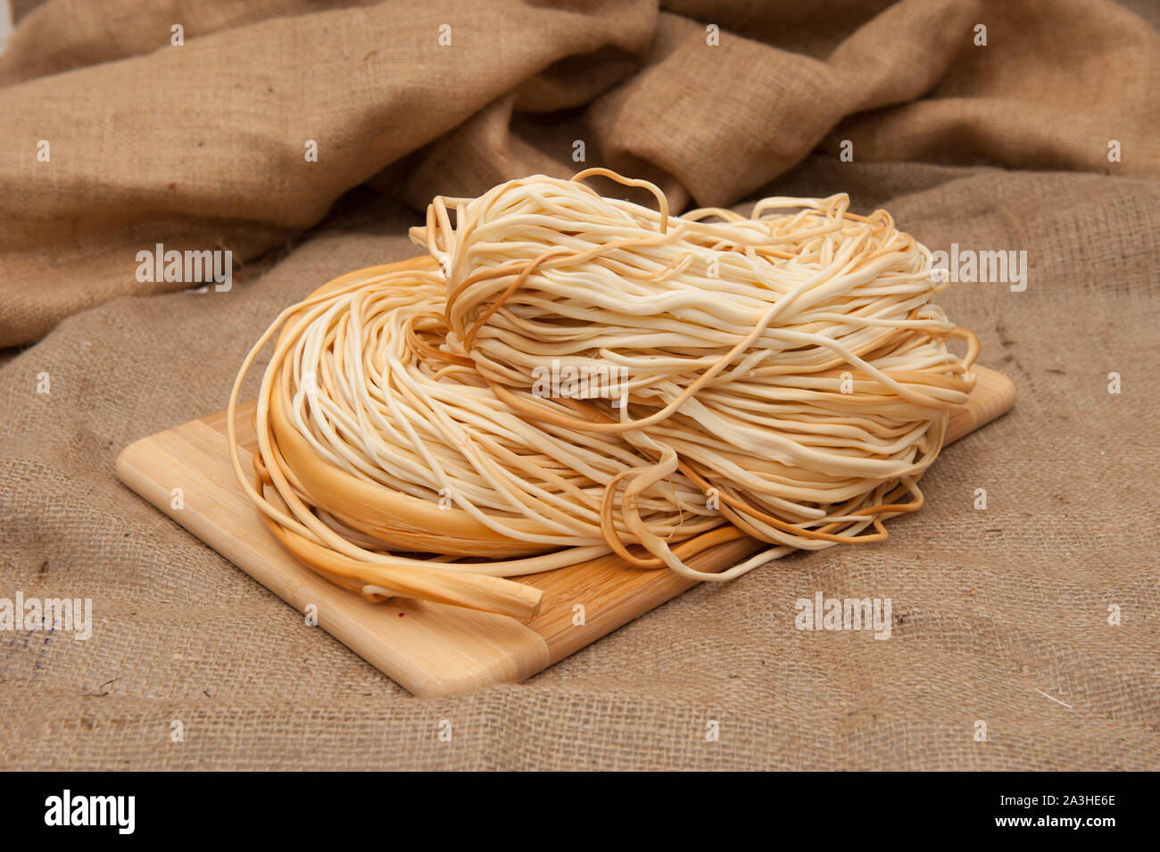 smoked cheese pigtail on a wooden board on white background Stock Photo ...