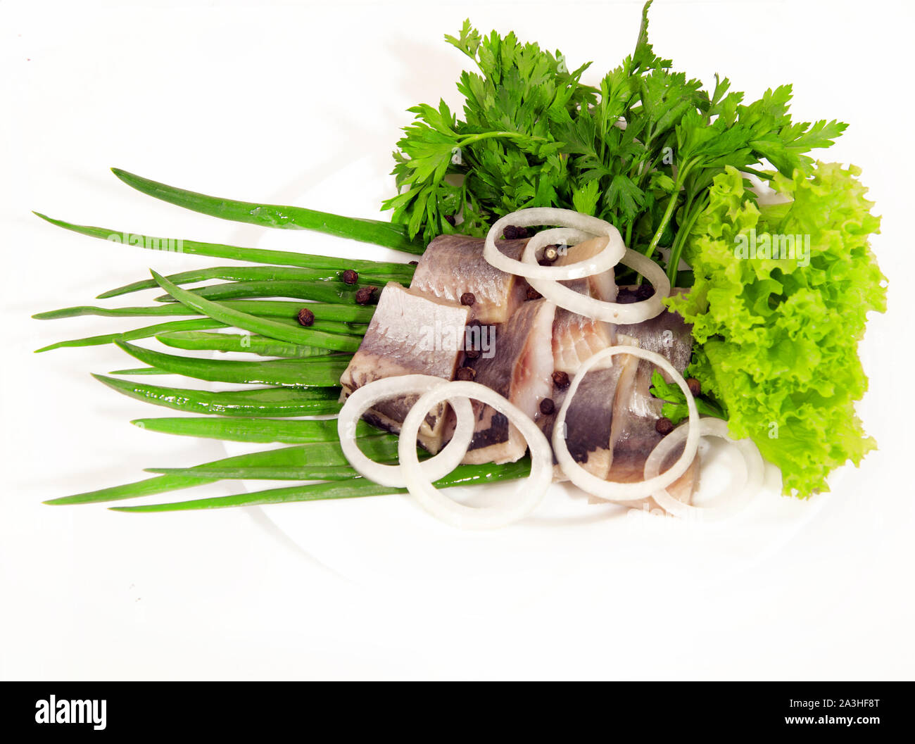 Salted herring fish with onions, herbs, spices on a white background ...