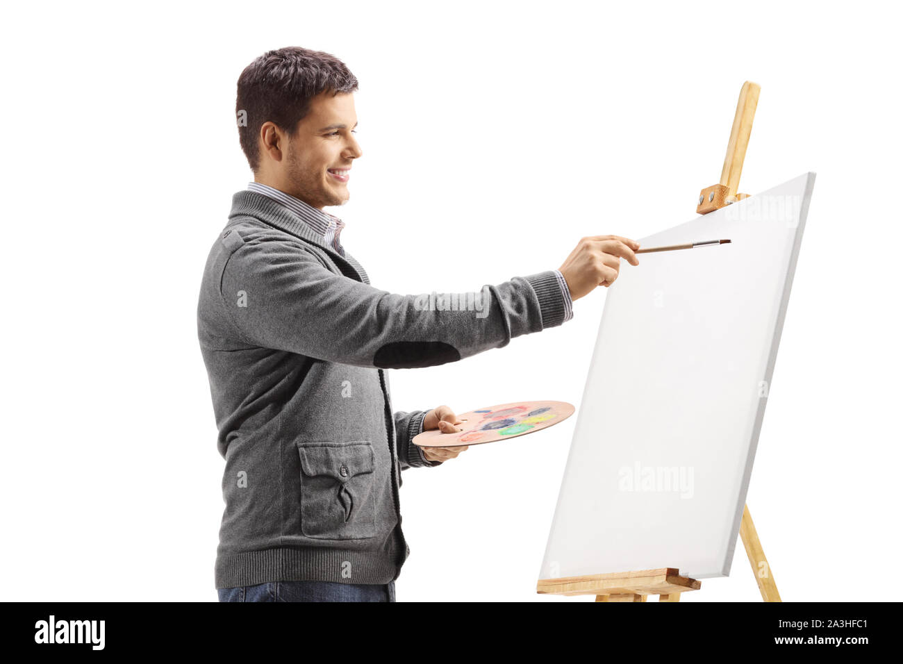 Young man painting on a canvas isolated on white background Stock Photo ...