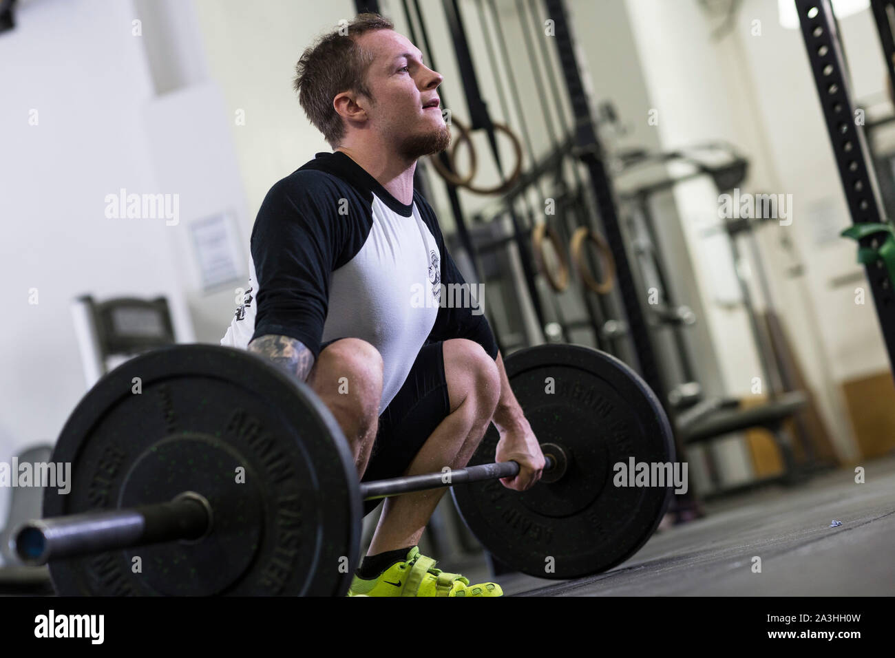 A young white male athlete performs various lifts and bodyweight ...