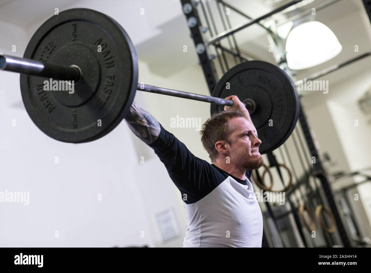 A young white male athlete performs various lifts and bodyweight ...
