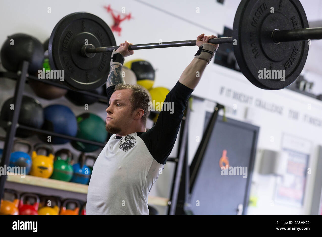 A young white male athlete performs various lifts and bodyweight ...