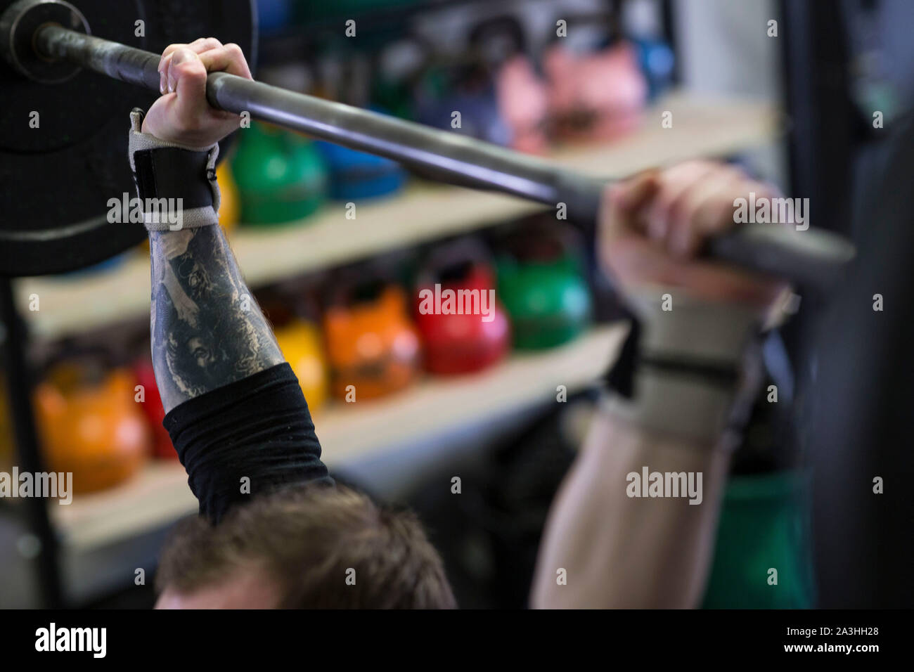 A young white male athlete performs various lifts and bodyweight ...