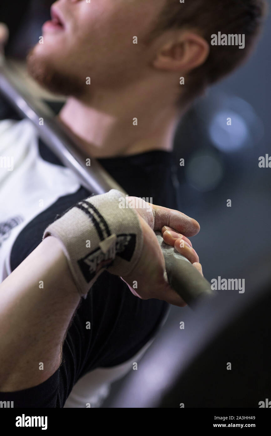 A young white male athlete performs various lifts and bodyweight ...