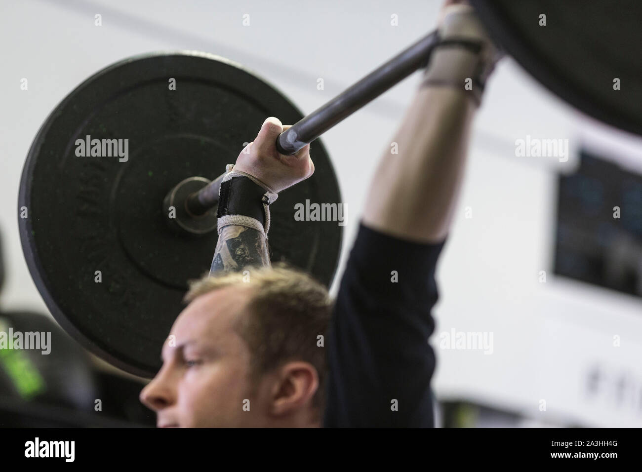 A young white male athlete performs various lifts and bodyweight ...