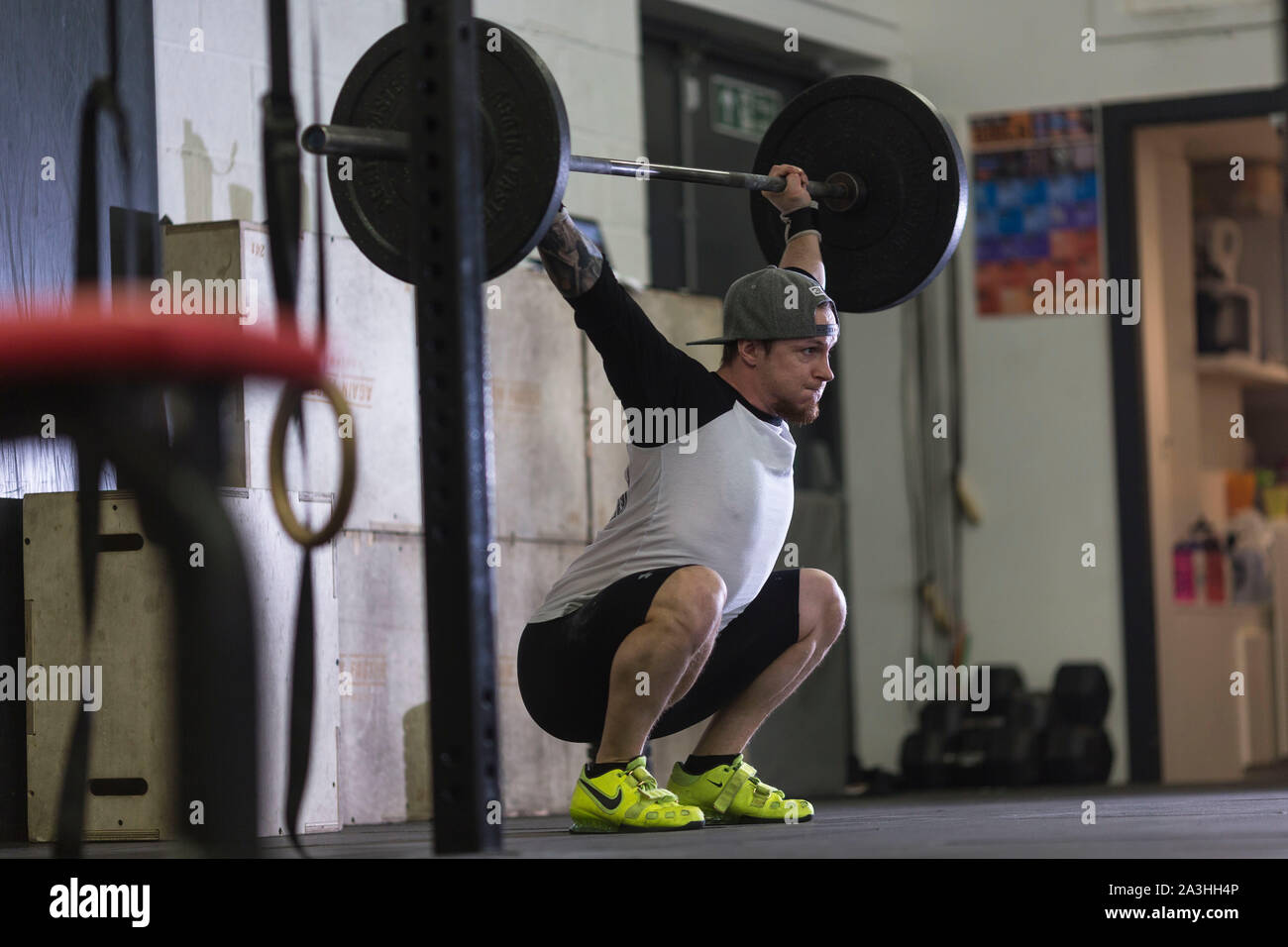 A young white male athlete performs various lifts and bodyweight ...