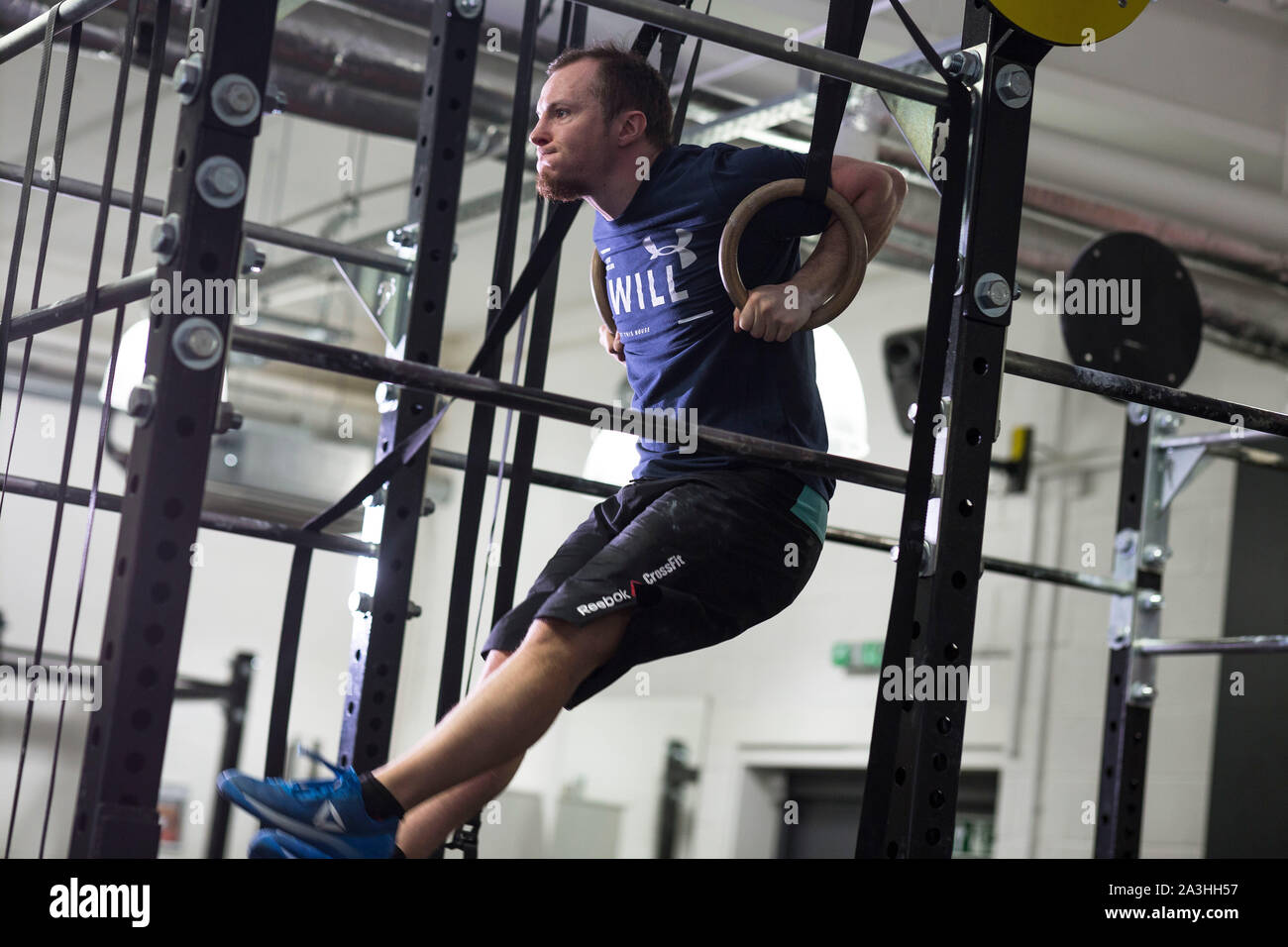 A young white male athlete performs various lifts and bodyweight ...