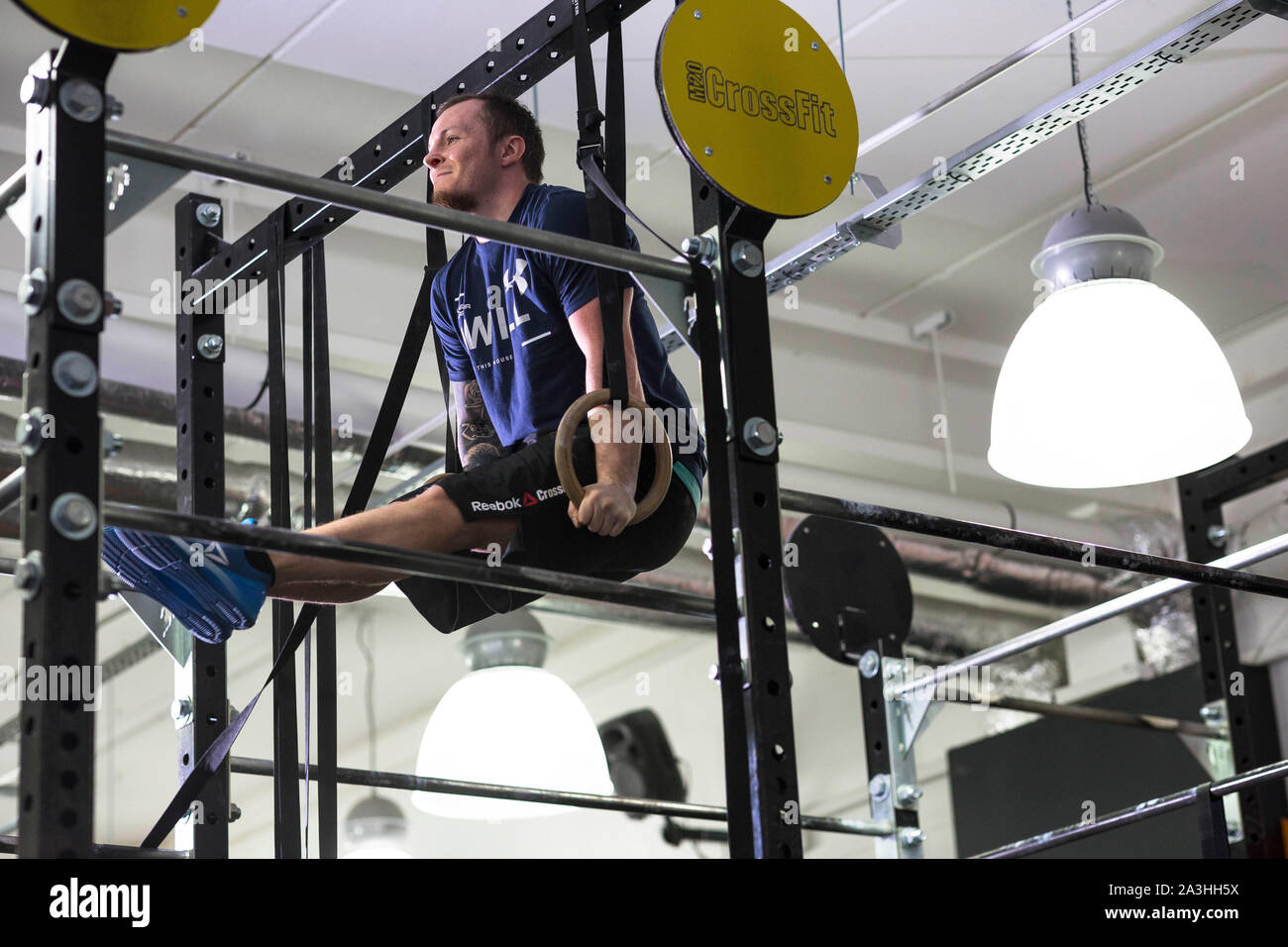 A young white male athlete performs various lifts and bodyweight ...
