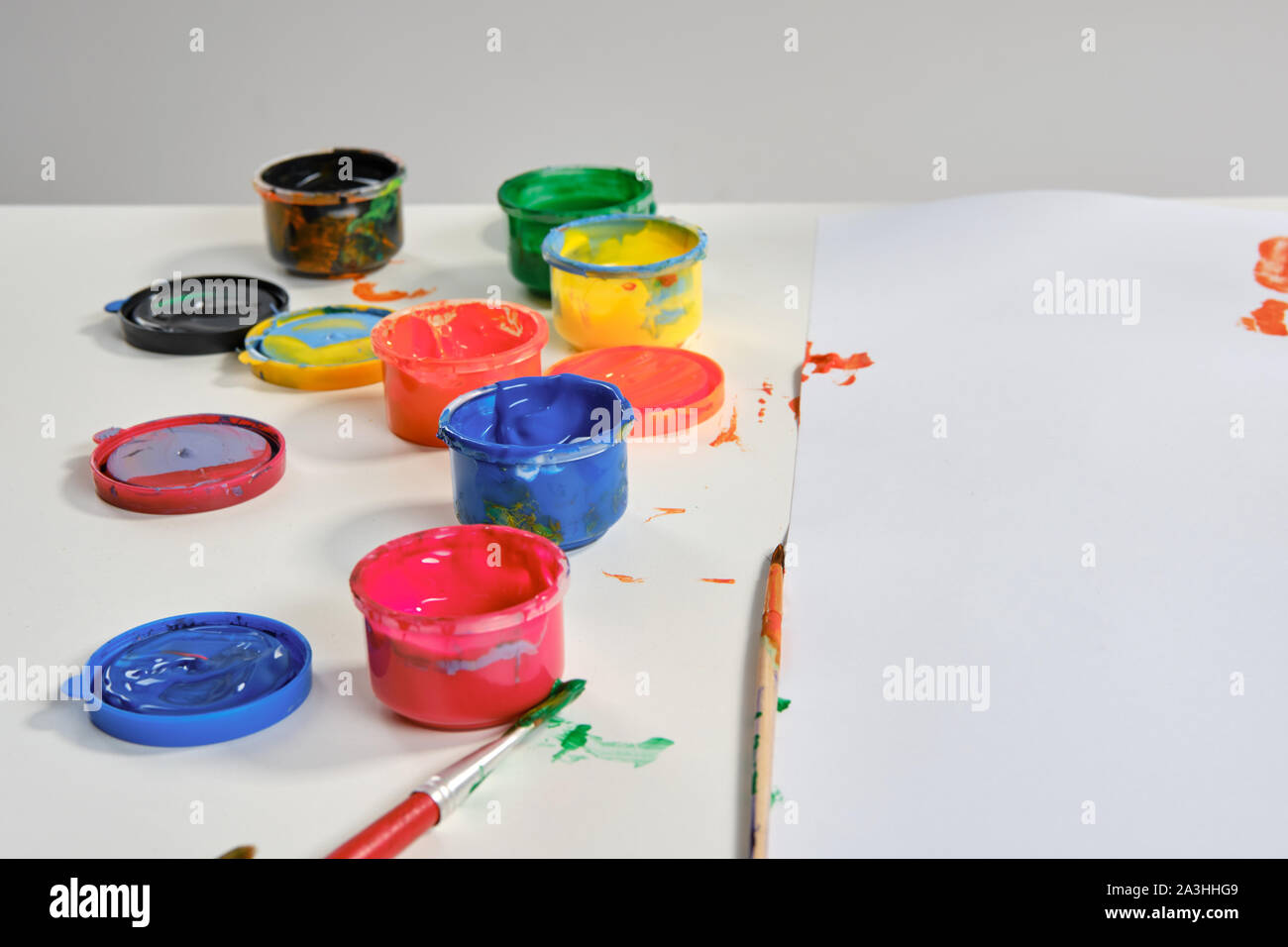 Colorful paints are standing on a table with a whatman. Art studio ...