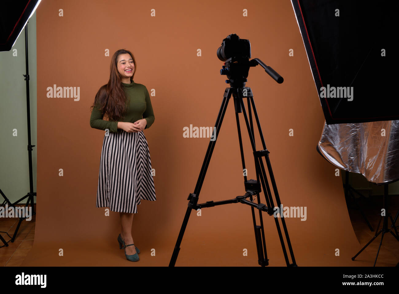 Young beautiful Indian woman vlogging against brown background Stock ...