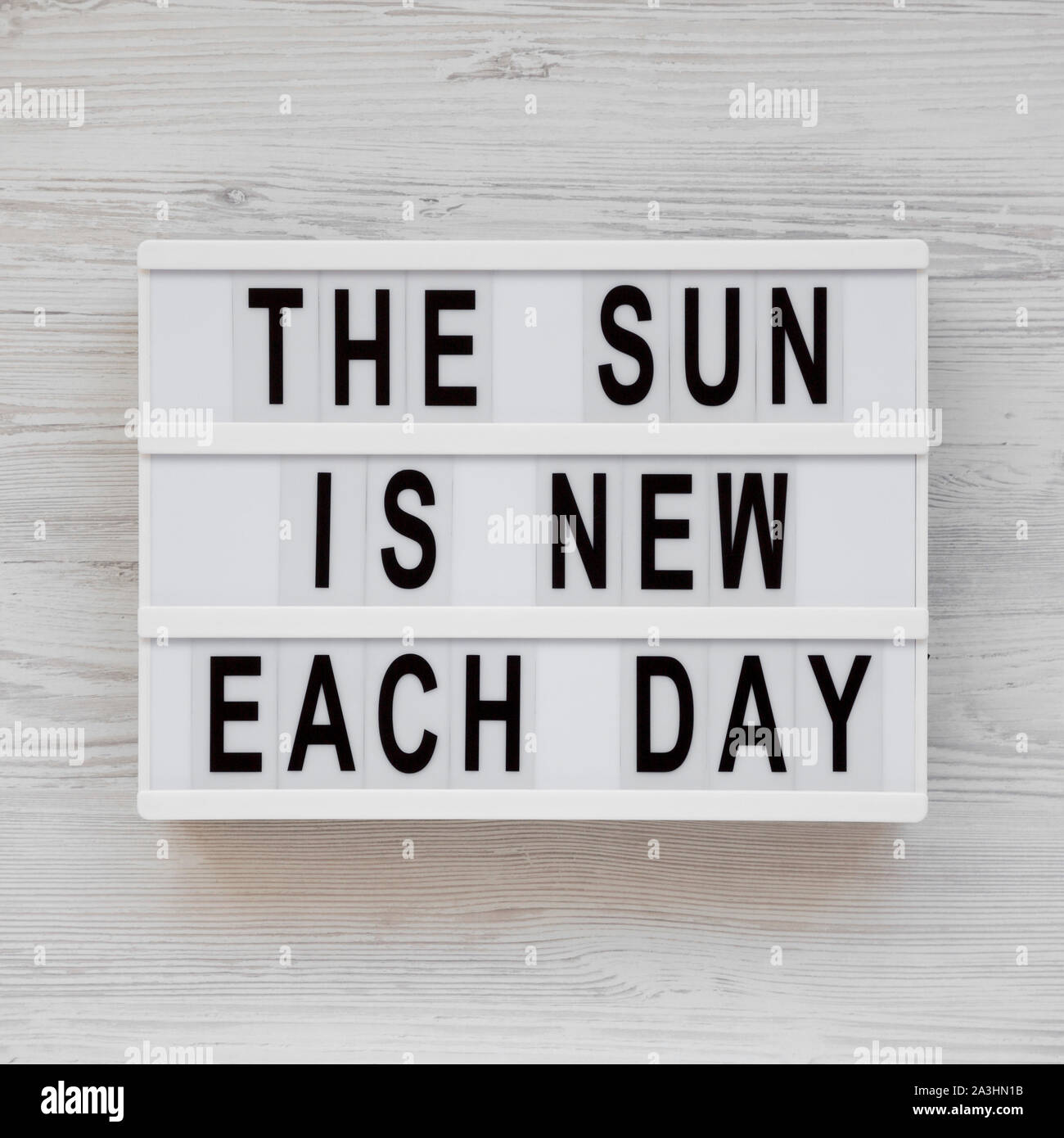 'The sun is new each day' words on a modern board on a white wooden ...