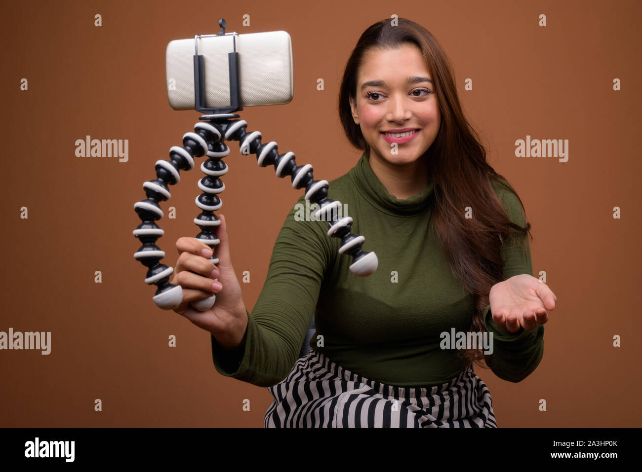 Young beautiful Indian woman vlogging with mobile phone against Stock ...