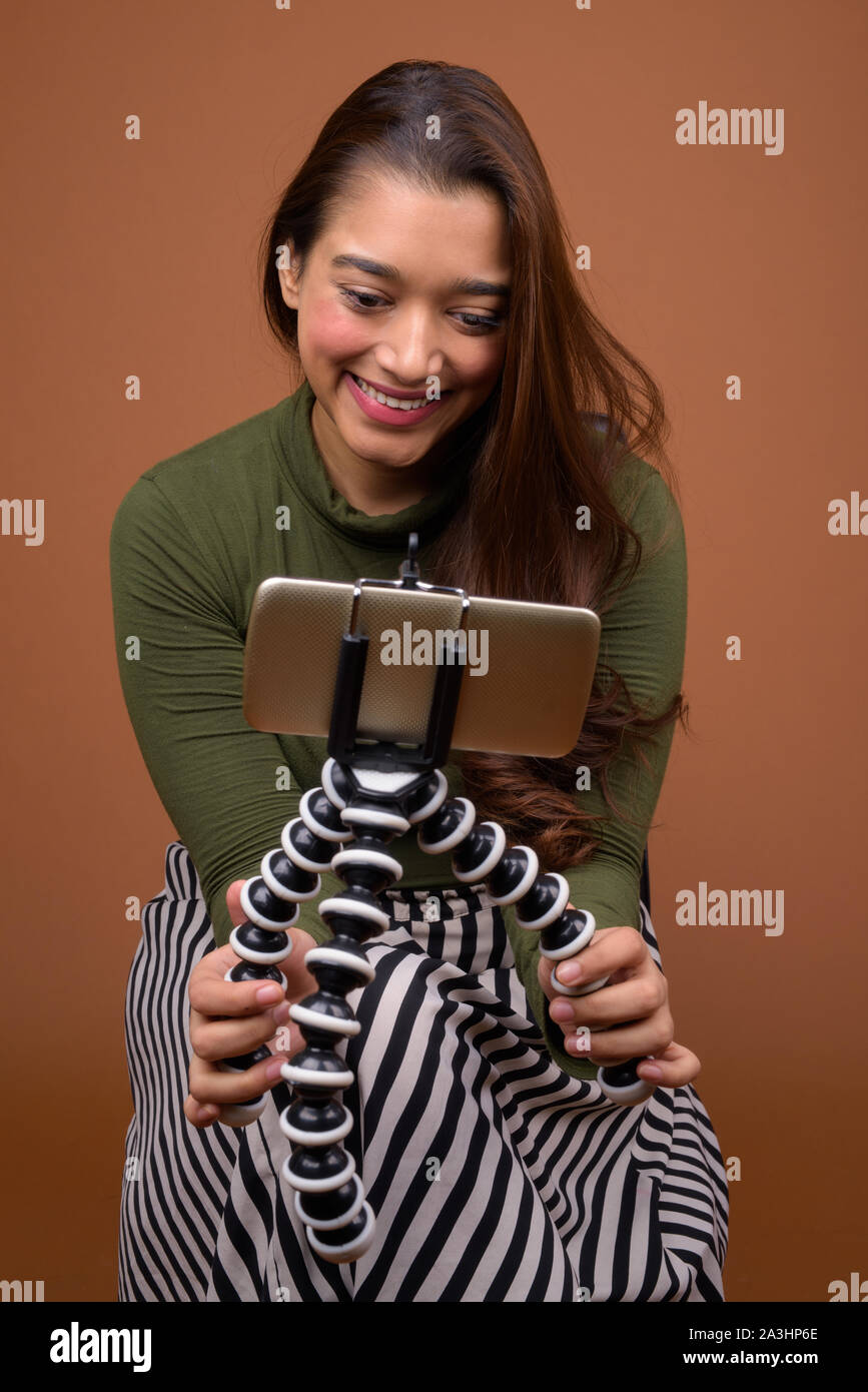 Young beautiful Indian woman vlogging with mobile phone against Stock ...