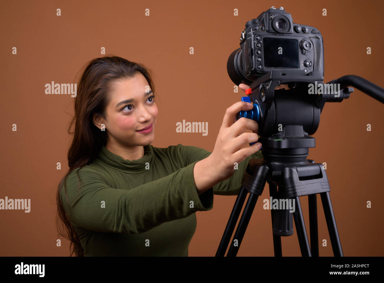 Young beautiful Indian woman vlogging against brown background Stock ...