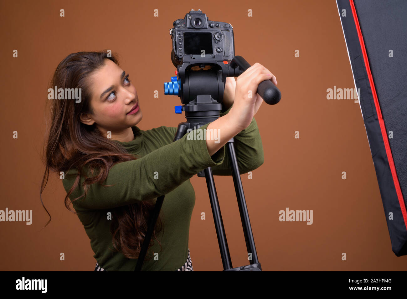 Young beautiful Indian woman vlogging against brown background Stock ...
