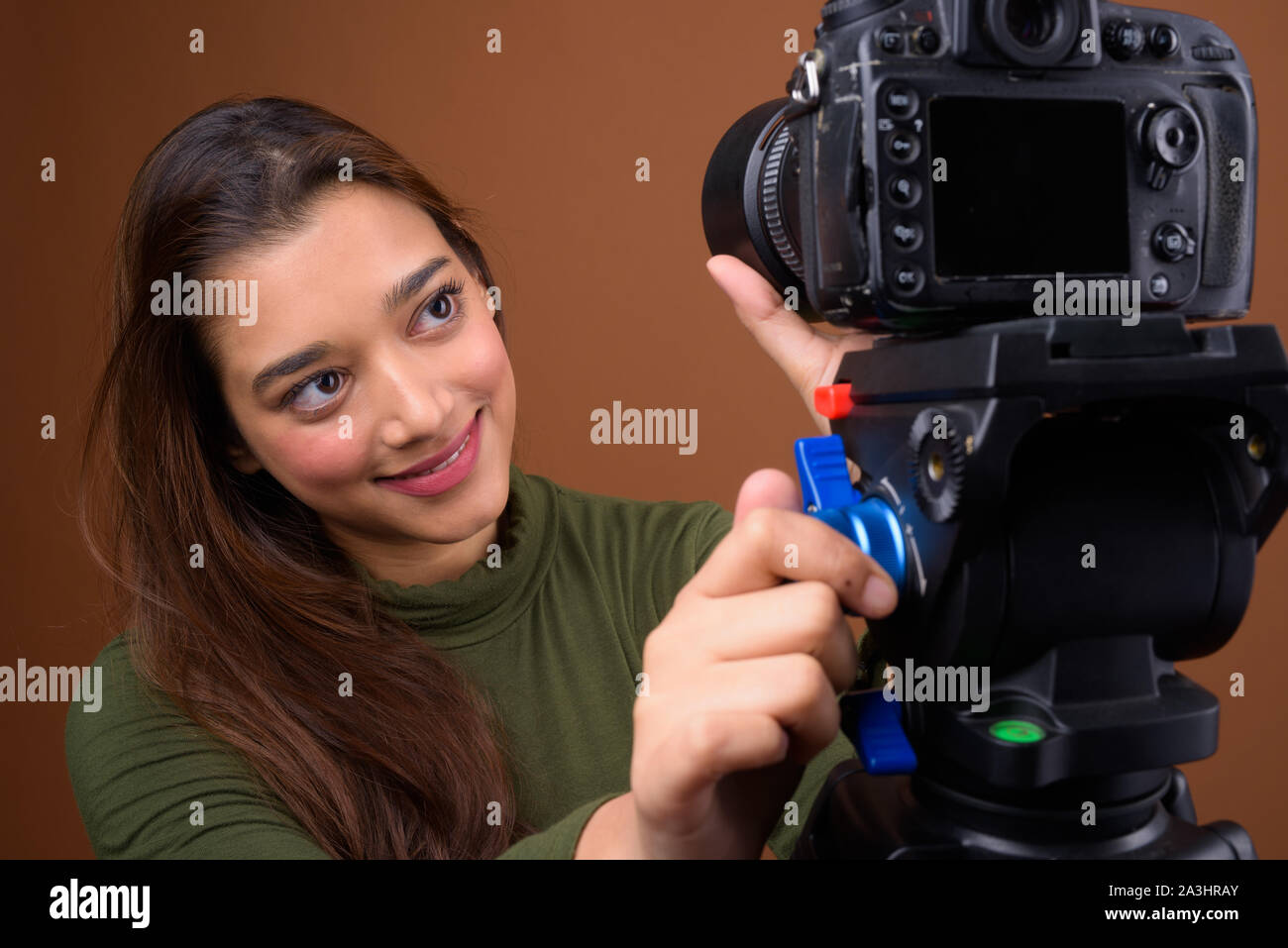 Young beautiful Indian woman vlogging against brown background Stock ...
