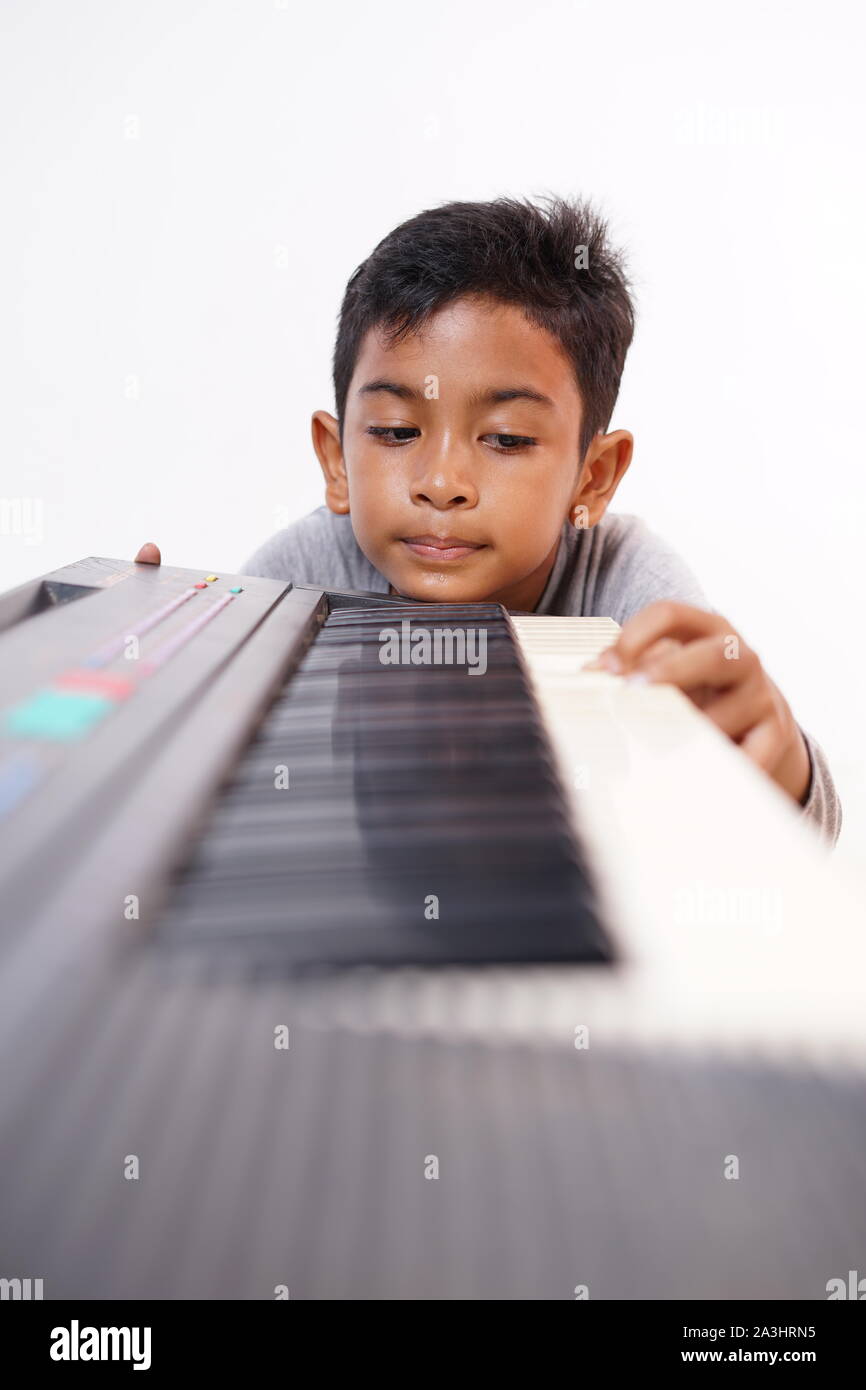 Boring little boy with practising piano lesson Stock Photo - Alamy