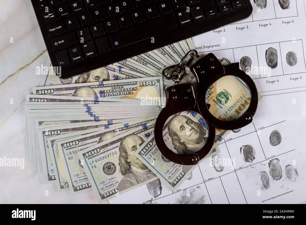 Cyber crime legal law police handcuffs on a hundred dollar bills with ...