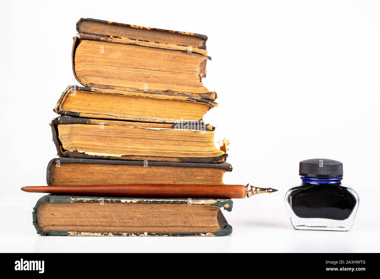 Old dusty books and writing nib on a bright countertop. Library items ...