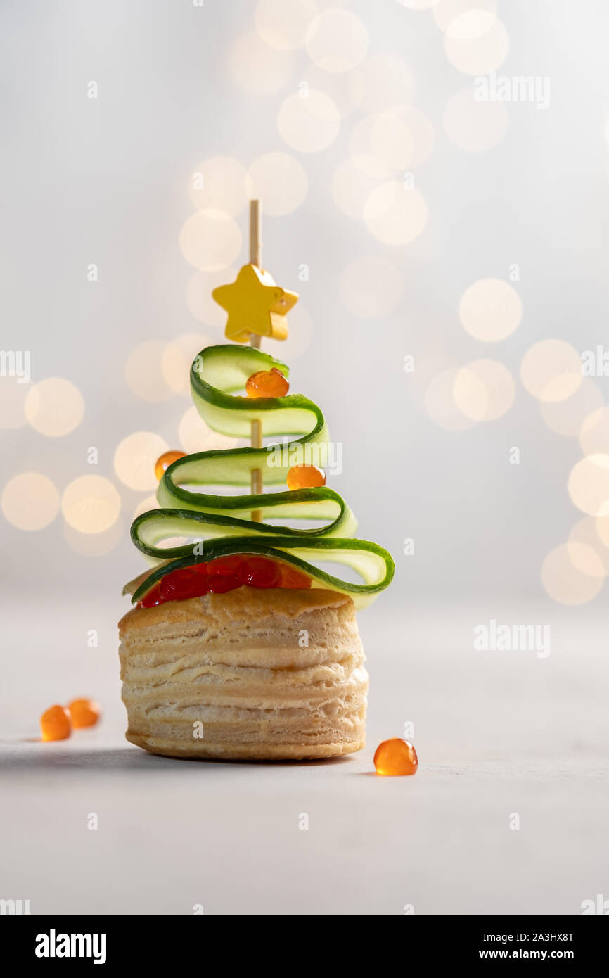 Christmas tree canape with cucumber slice, salmon pate and red caviar ...